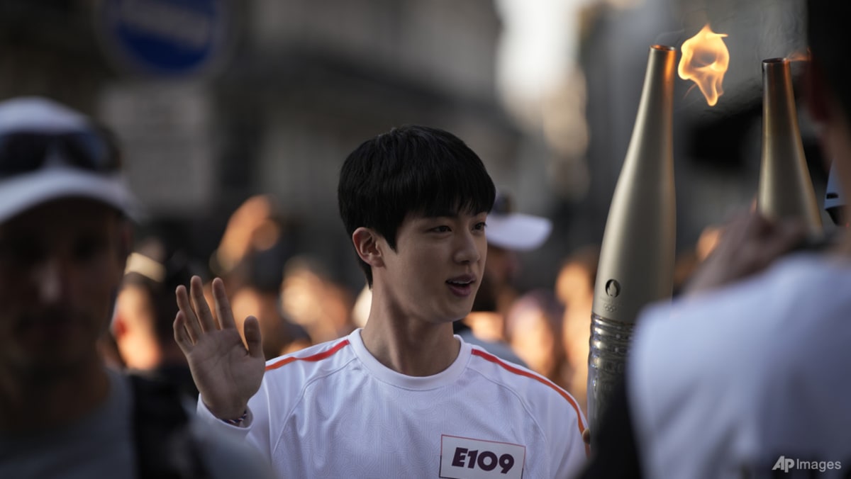 BTS member Jin carries Olympic torch in Paris near Louvre Museum - CNA ...