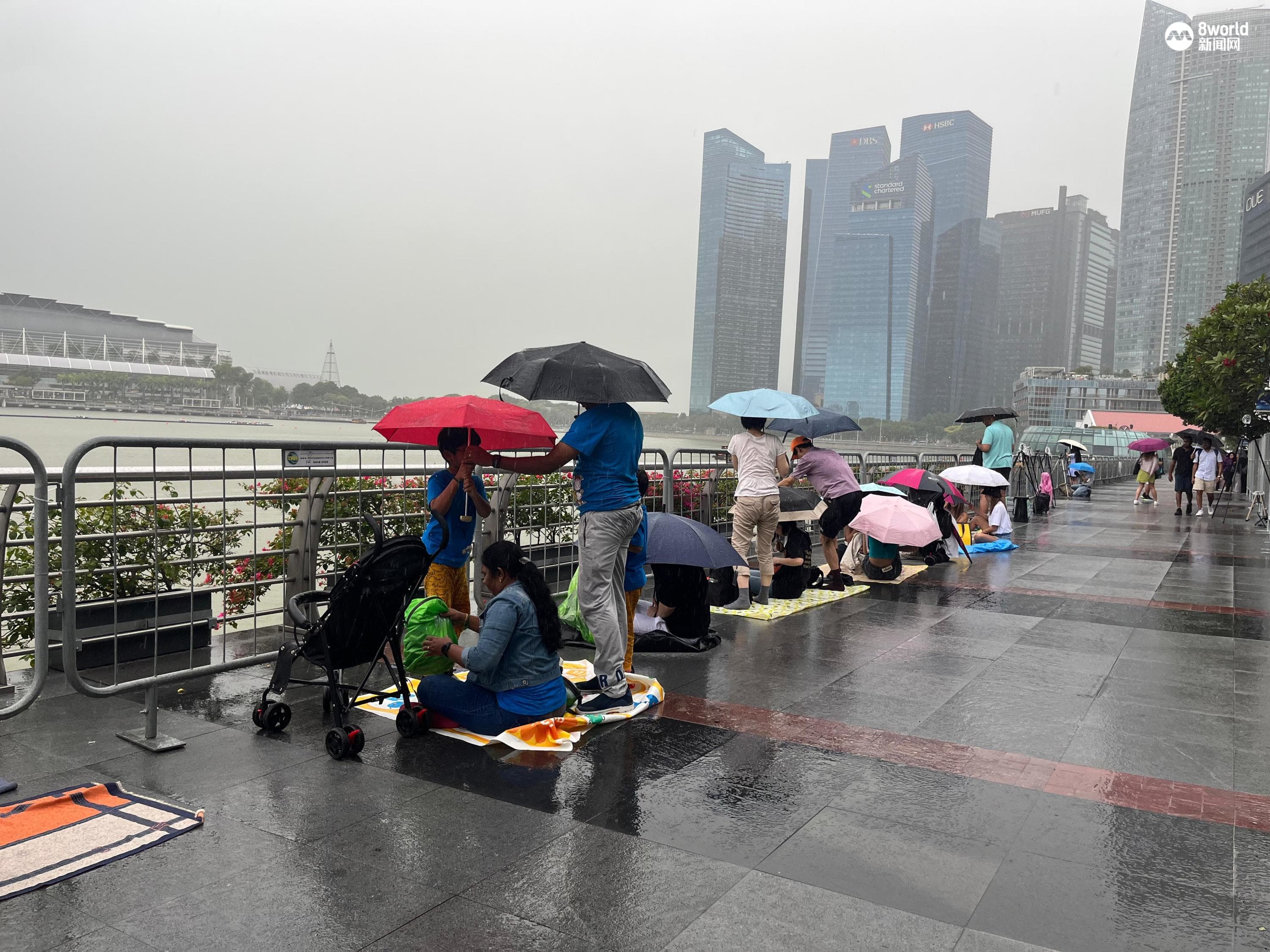 【直播】长时间撑伞占好位 大雨浇不走滨海湾跨年人潮 - 8world